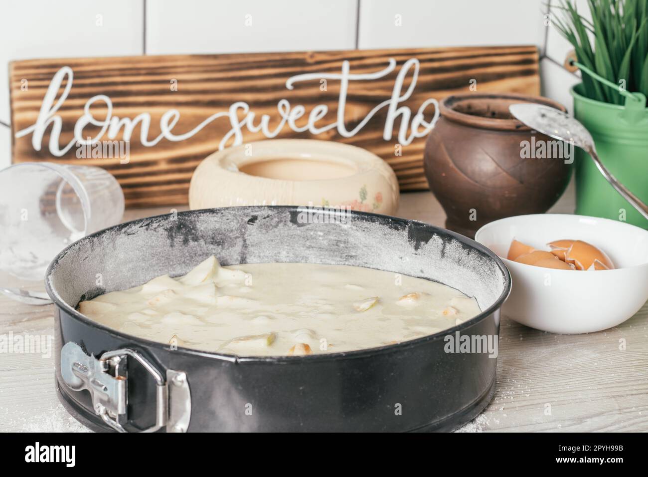 Baking dish with raw apple pie dough stands on kitchen counter next to ...