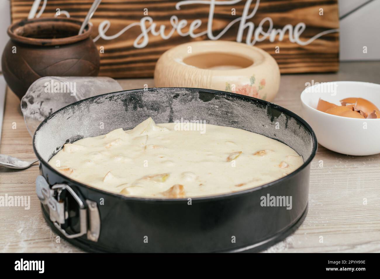 Baking dish with raw apple pie dough stands on kitchen counter next to ...