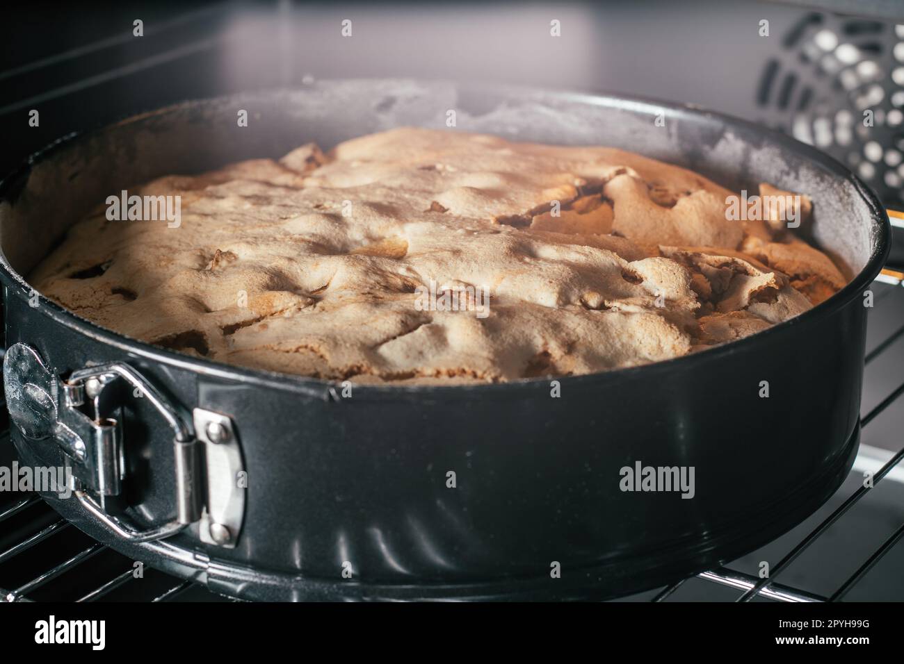 Baking dish with apple pie stands in black oven. Homemade seasonal ...