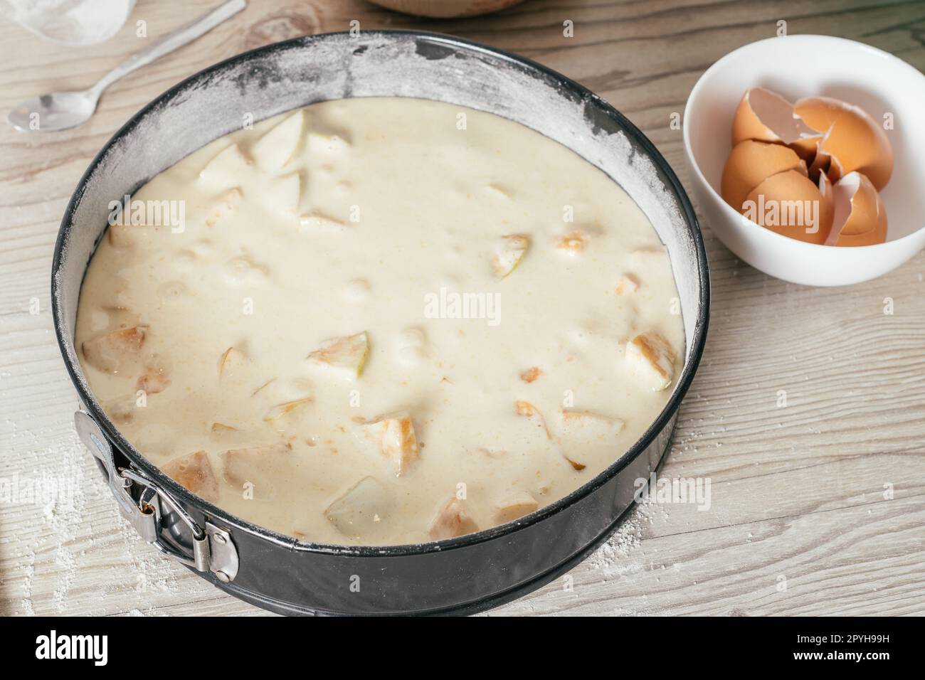Baking dish with raw apple pie dough stands on kitchen counter next to ...
