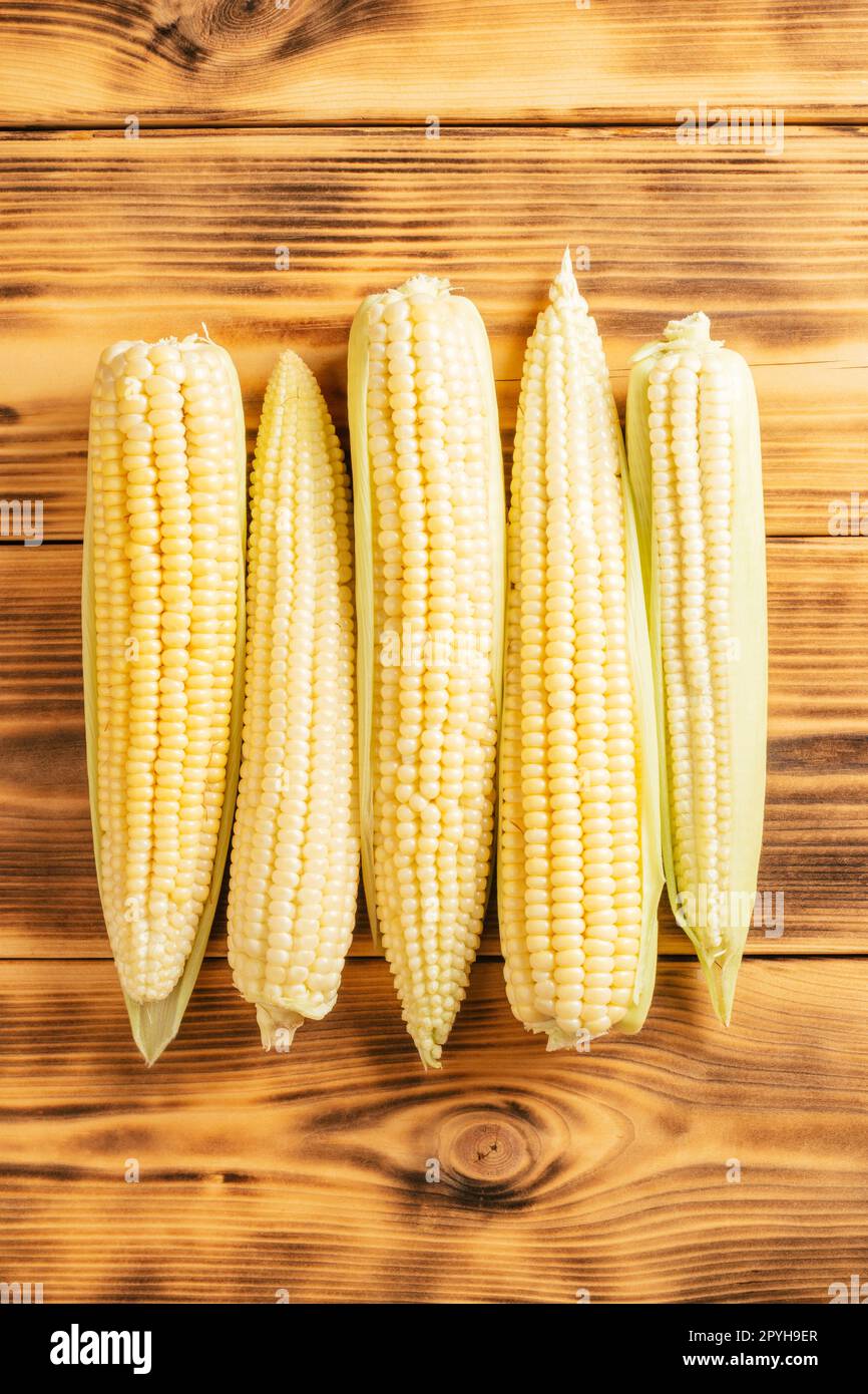 Five sweet yellow raw milk corn cobs maize with green fresh ingredient ...