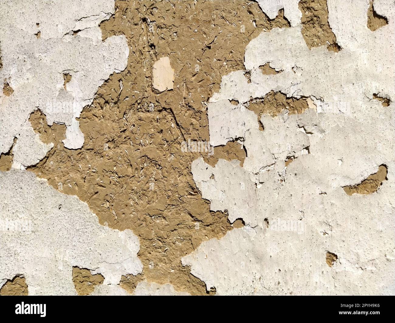 Close-up background of the wall of an old house made of clay mixed with ...