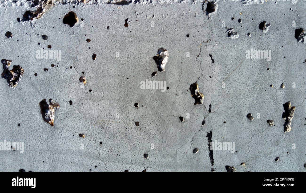 Concrete wall with concentric damage of large radius. Potholes ...