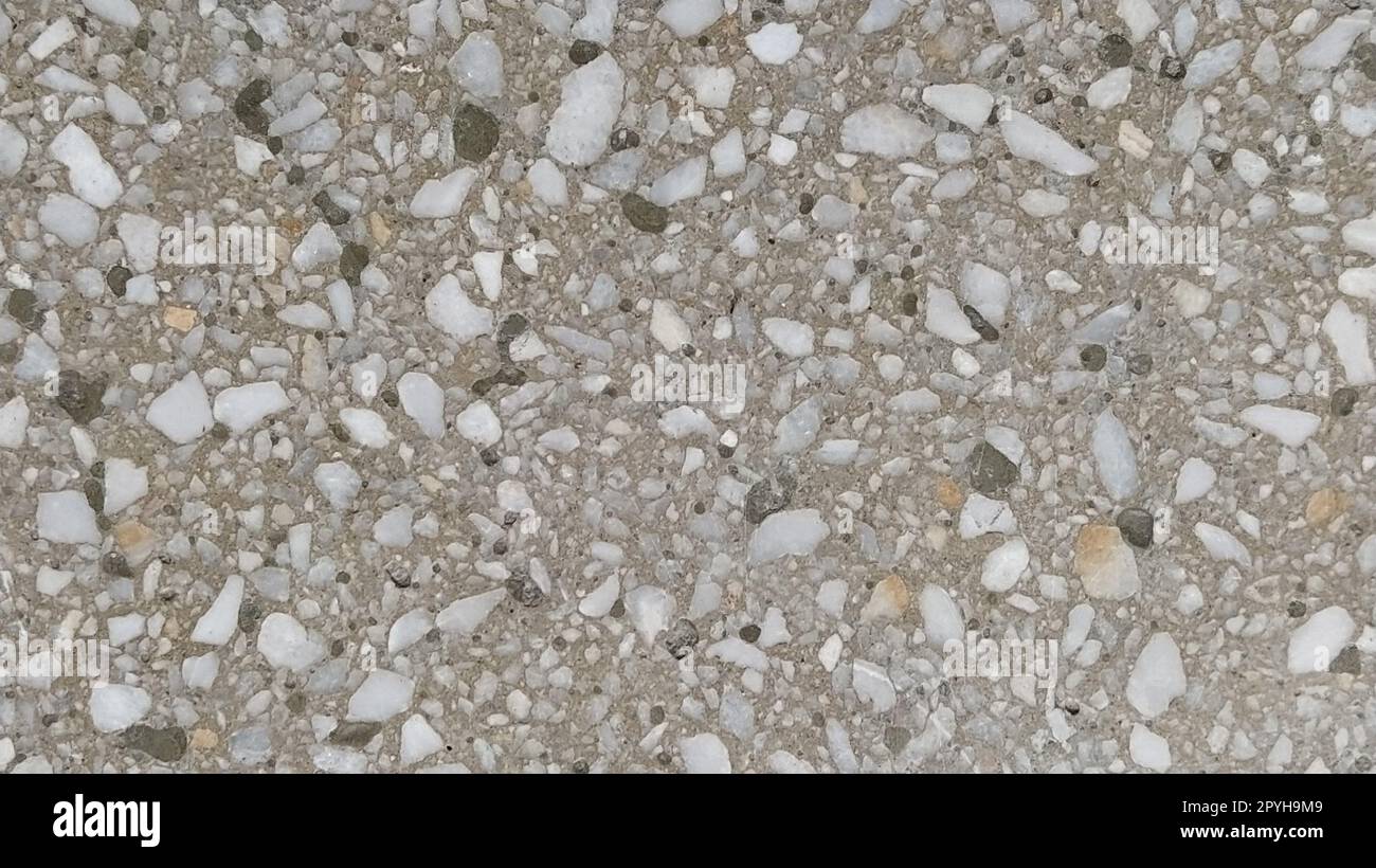 Concrete surface with multi-colored blotches of small stones. Light ...