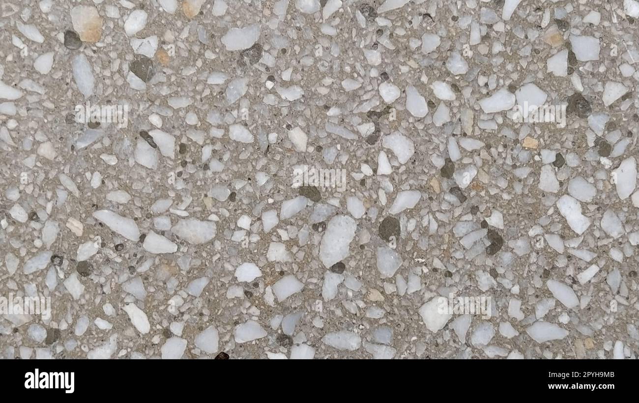 Concrete surface with multi-colored blotches of small stones. Light ...