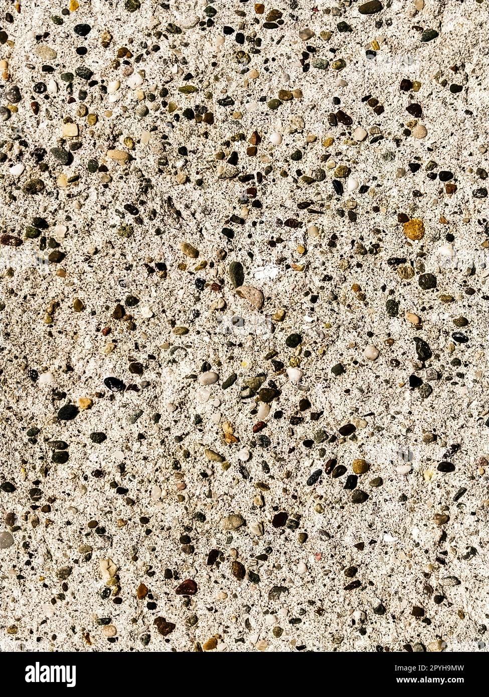 Concrete surface with multi-colored blotches of small stones. Light ...