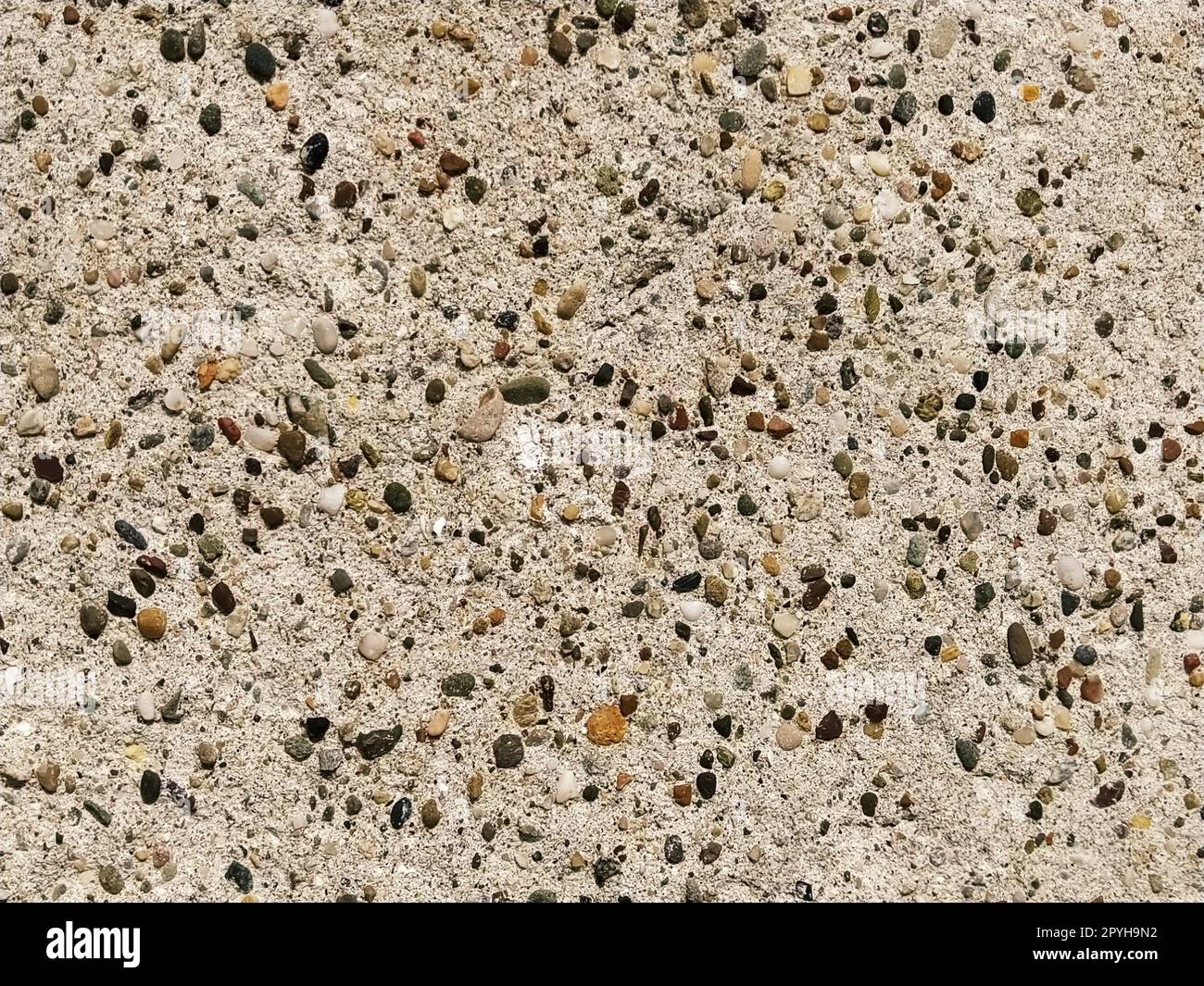 Concrete surface with multi-colored blotches of small stones. Light ...