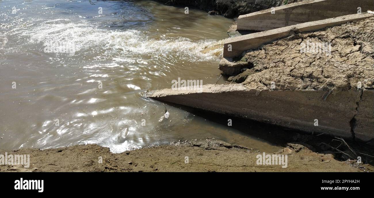 A large city drain drains sewage into a canal that flows into the river ...