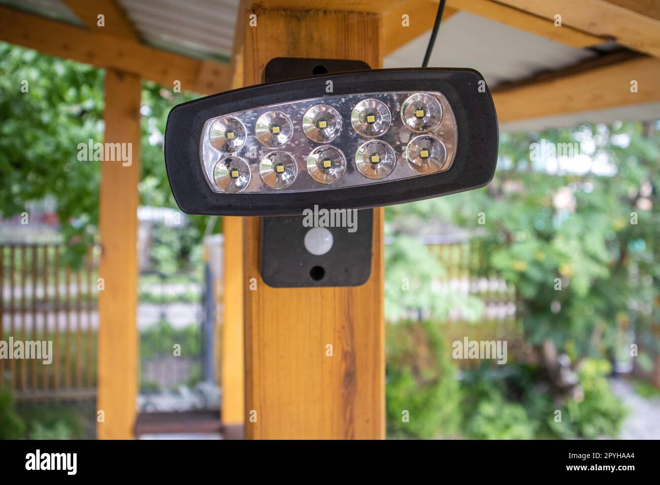 Close-up of an LED spotlight, a spotlight on a wooden post of an open ...