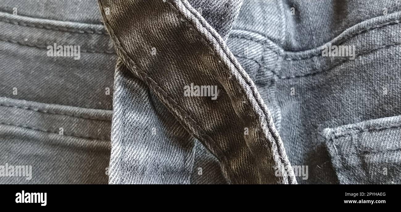 Fashionable denim clothing. Details and seams on rough denim. Black and ...
