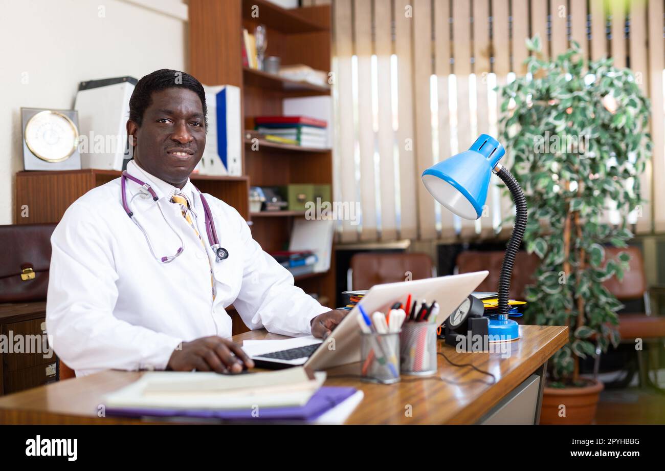 Doctor working in medical office using laptop Stock Photo - Alamy