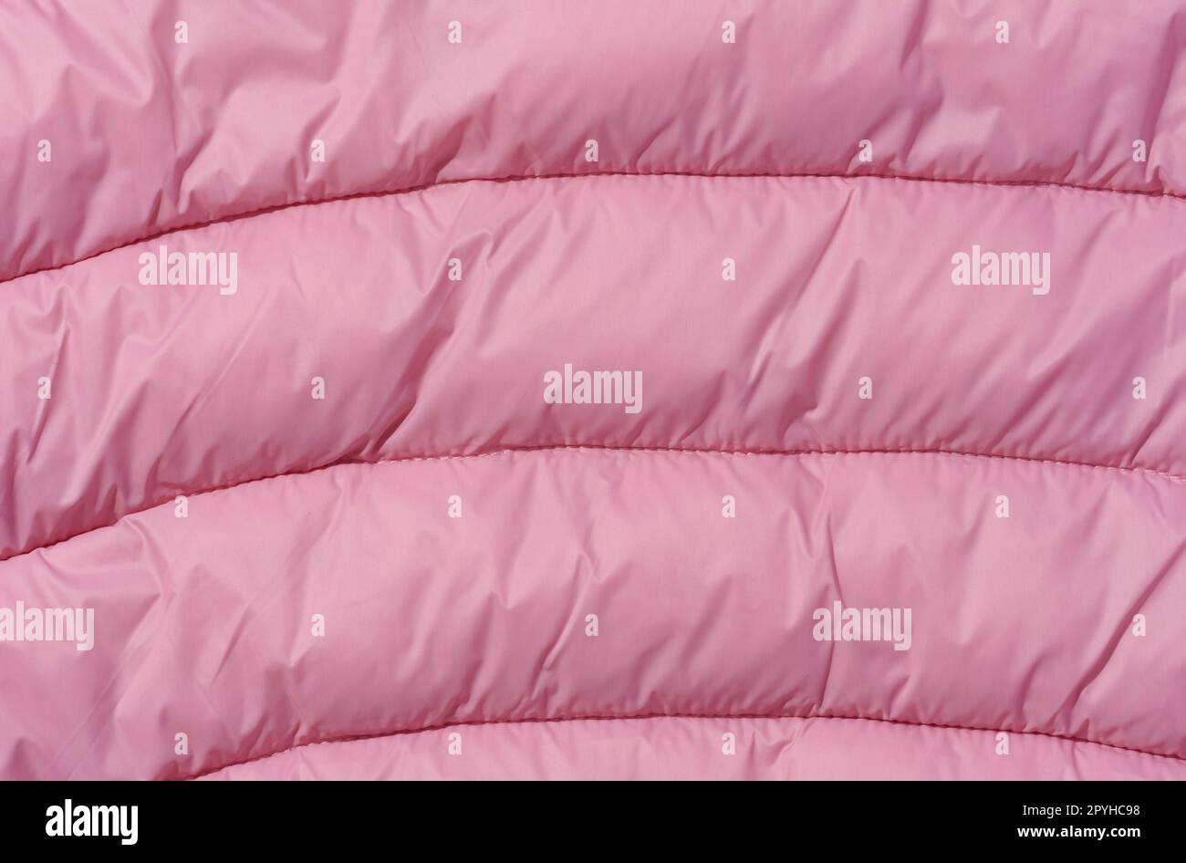 A fragment of pink fabric with down filling and stitching, fabric for ...