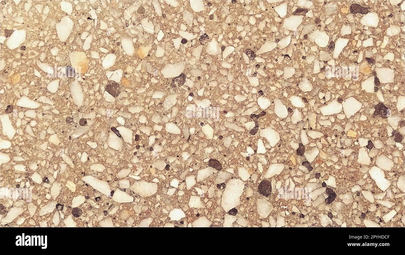 Concrete surface with multi-colored spots of small stones. Beige or ...