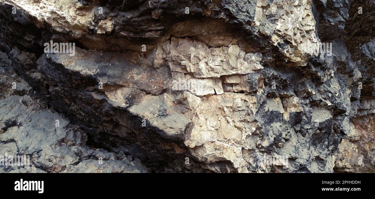Stone black rock close-up. Ancient frozen lava. Layers and strata of ...