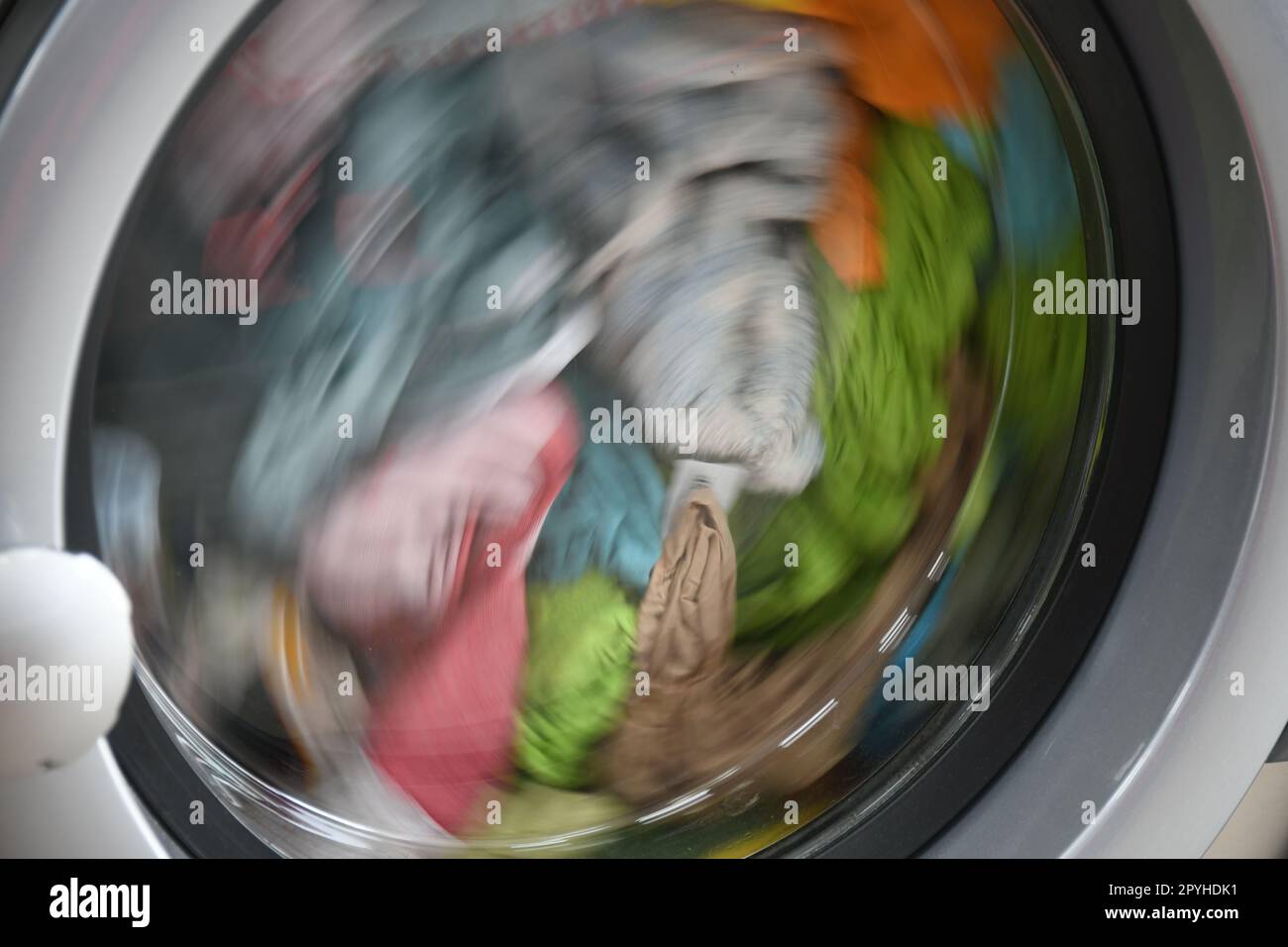 a stainless steel washing machine drum filled with colorful laundry ...