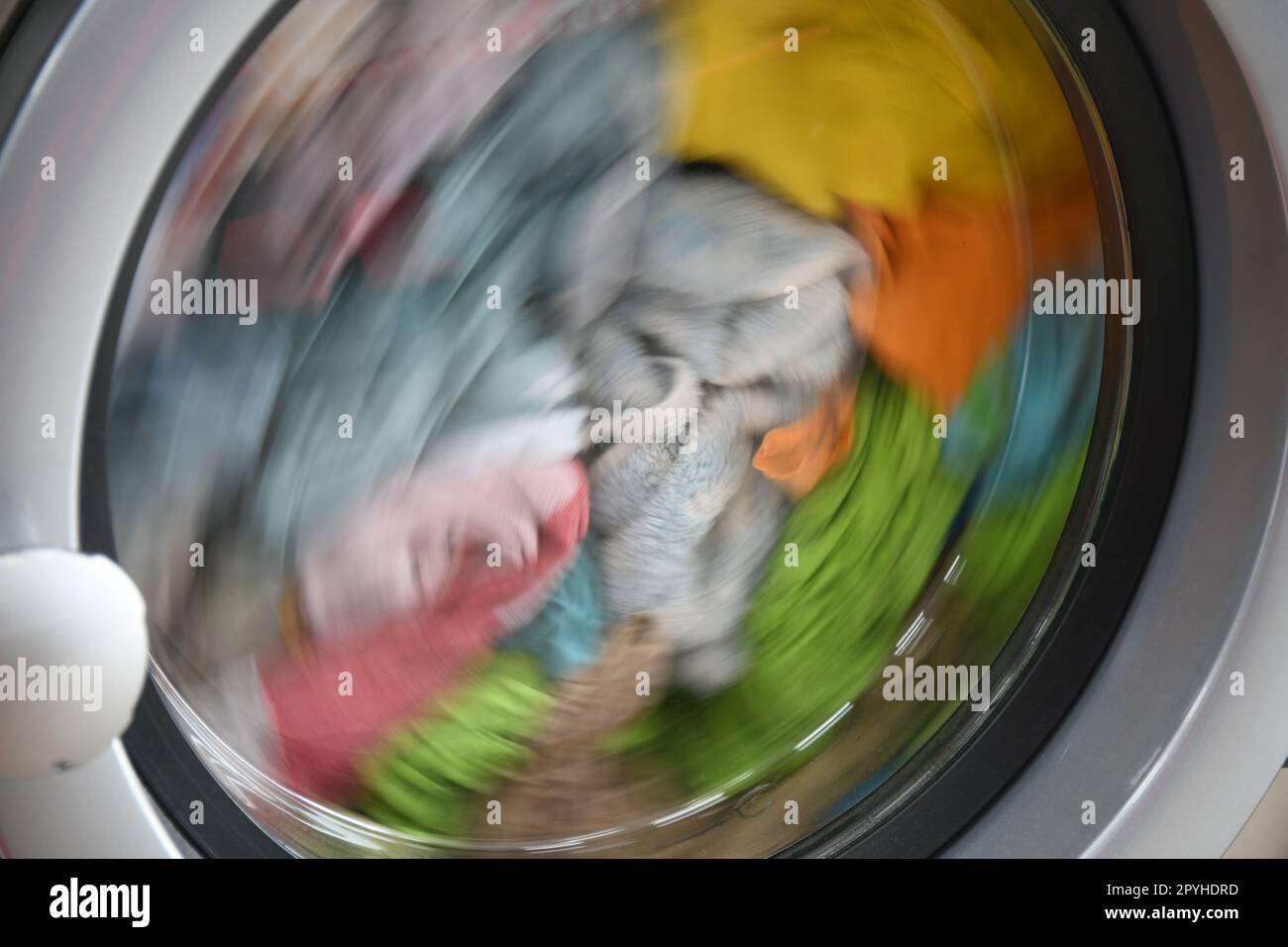 a stainless steel washing machine drum filled with colorful laundry ...