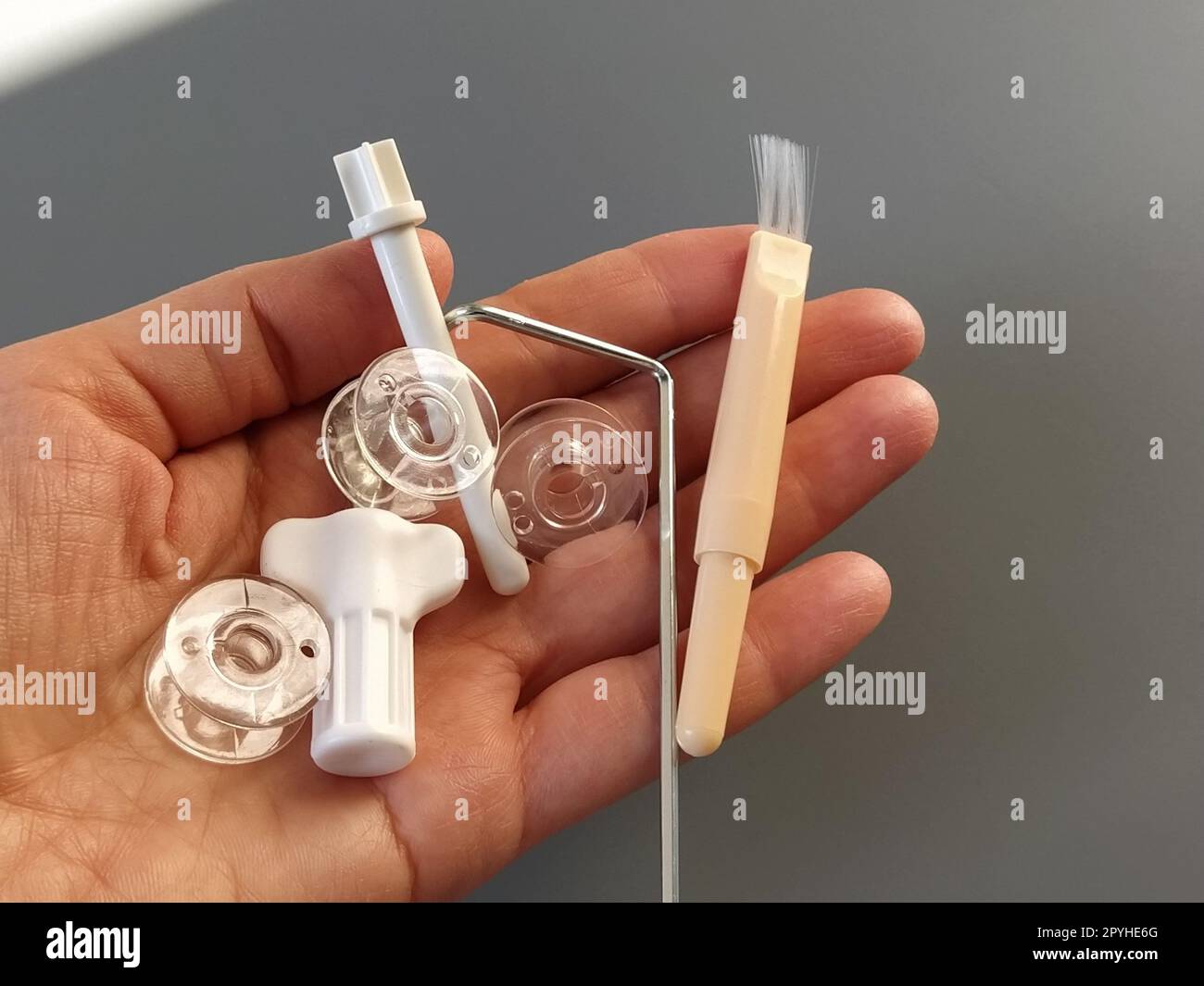 Transparent plastic bobbins from a modern sewing machine in the palm of ...