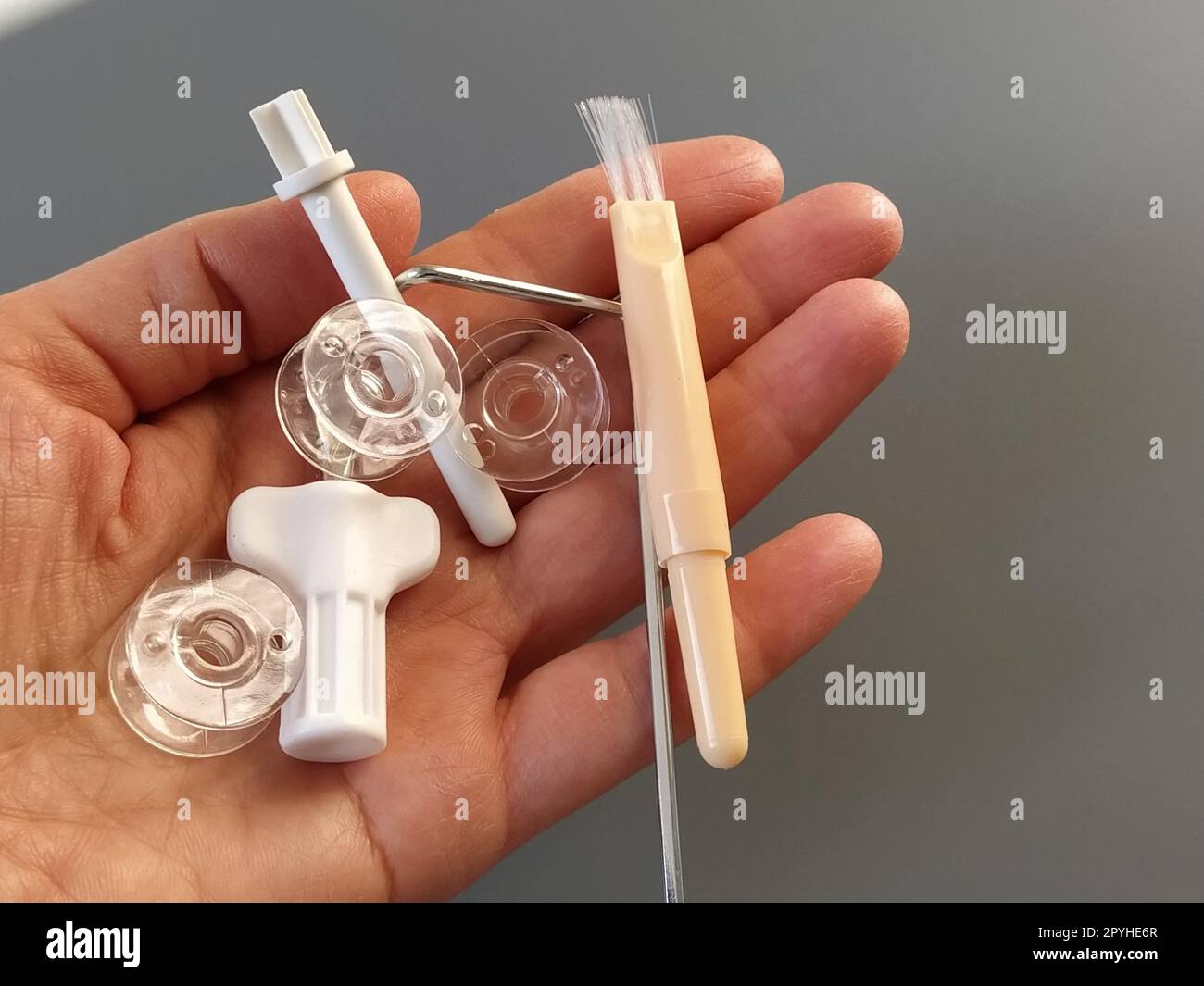 Transparent plastic bobbins from a modern sewing machine in the palm of ...