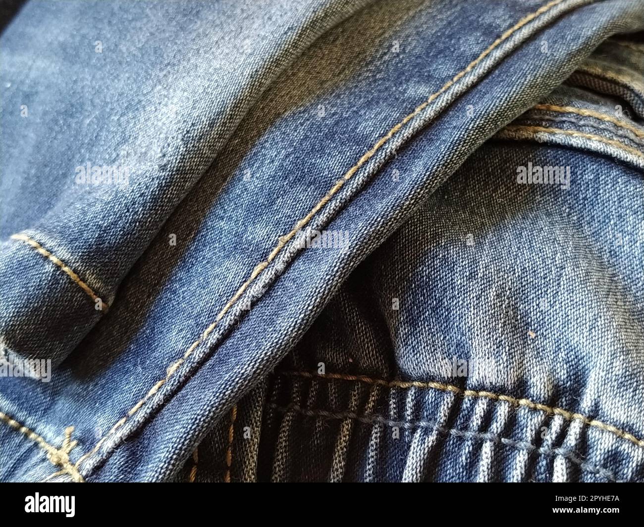 Denim fabric with seams made with red or beige threads close-up ...