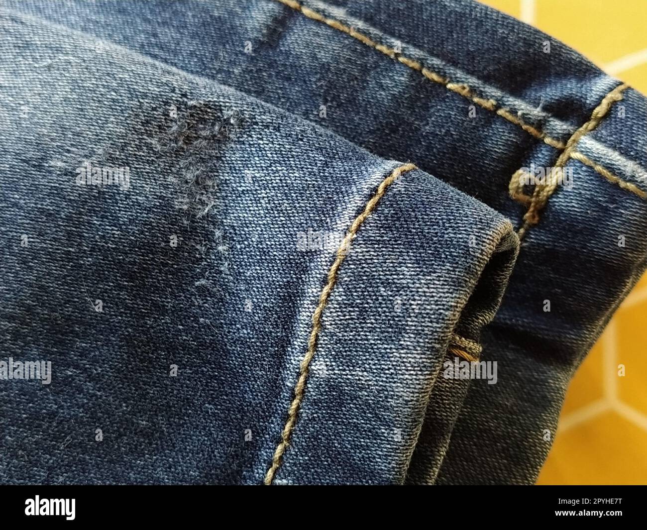 Denim fabric with seams made with red or beige threads close-up ...