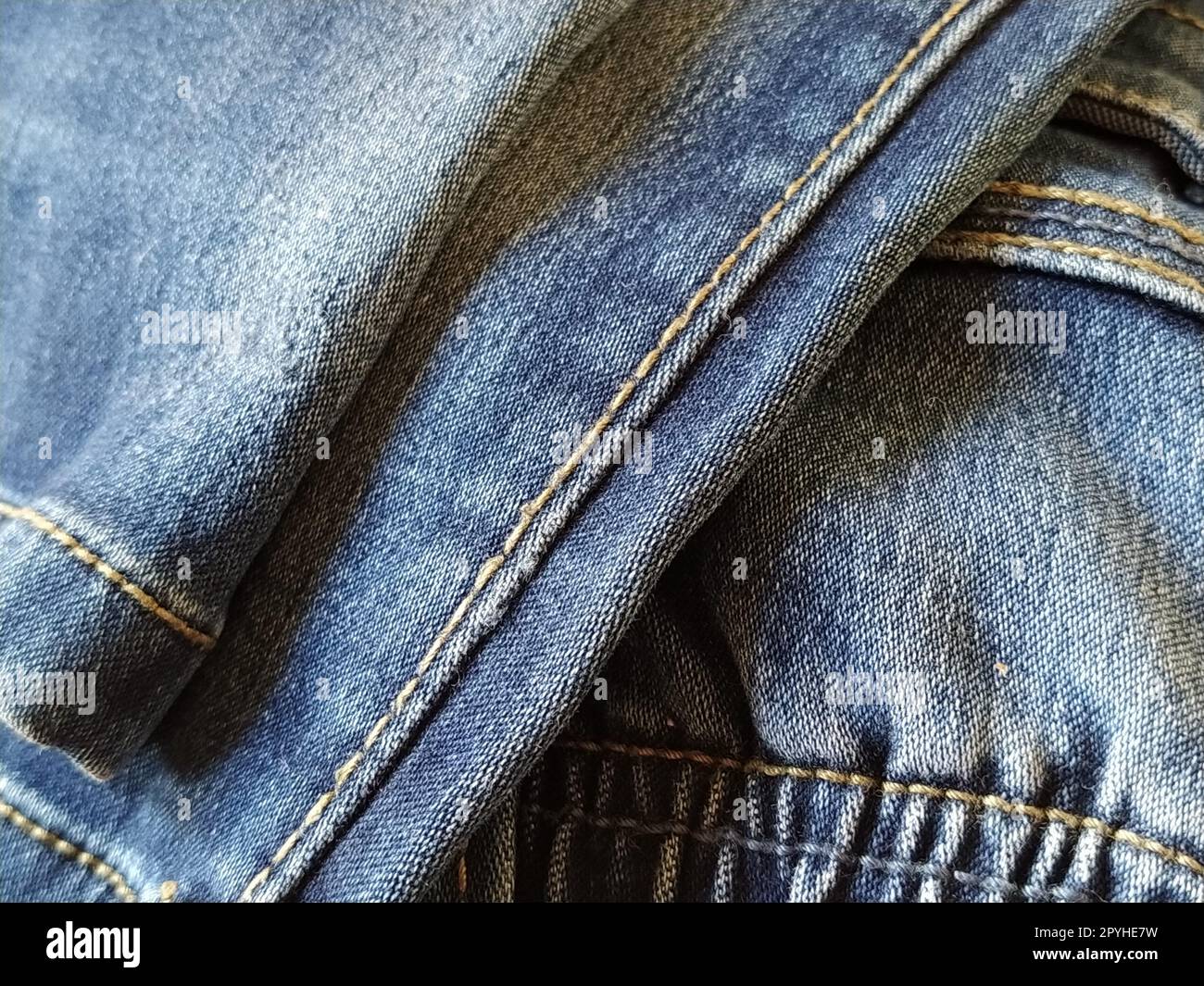 Denim fabric with seams made with red or beige threads close-up ...
