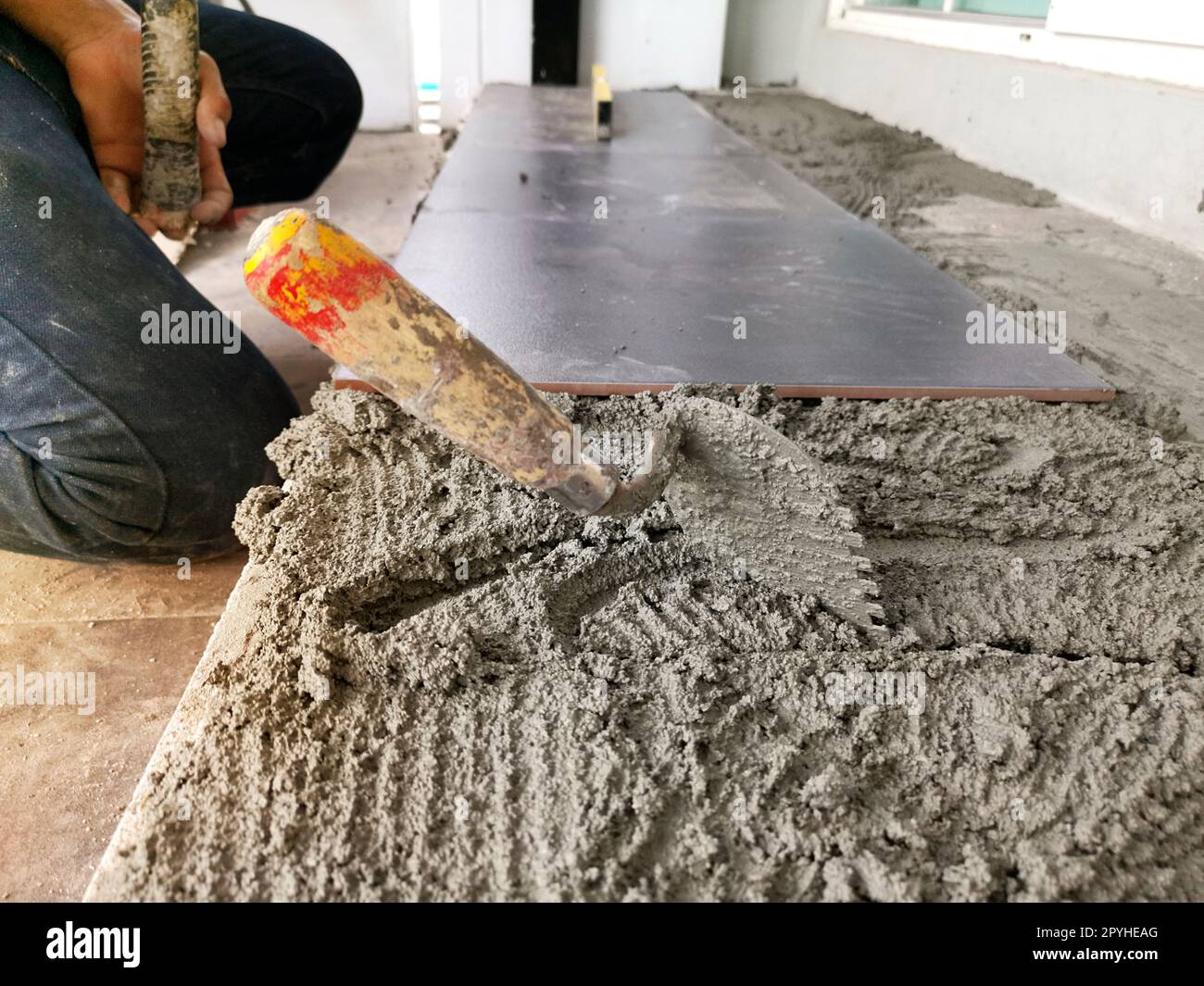 Close-up Installing tiles floor in construction work Stock Photo - Alamy