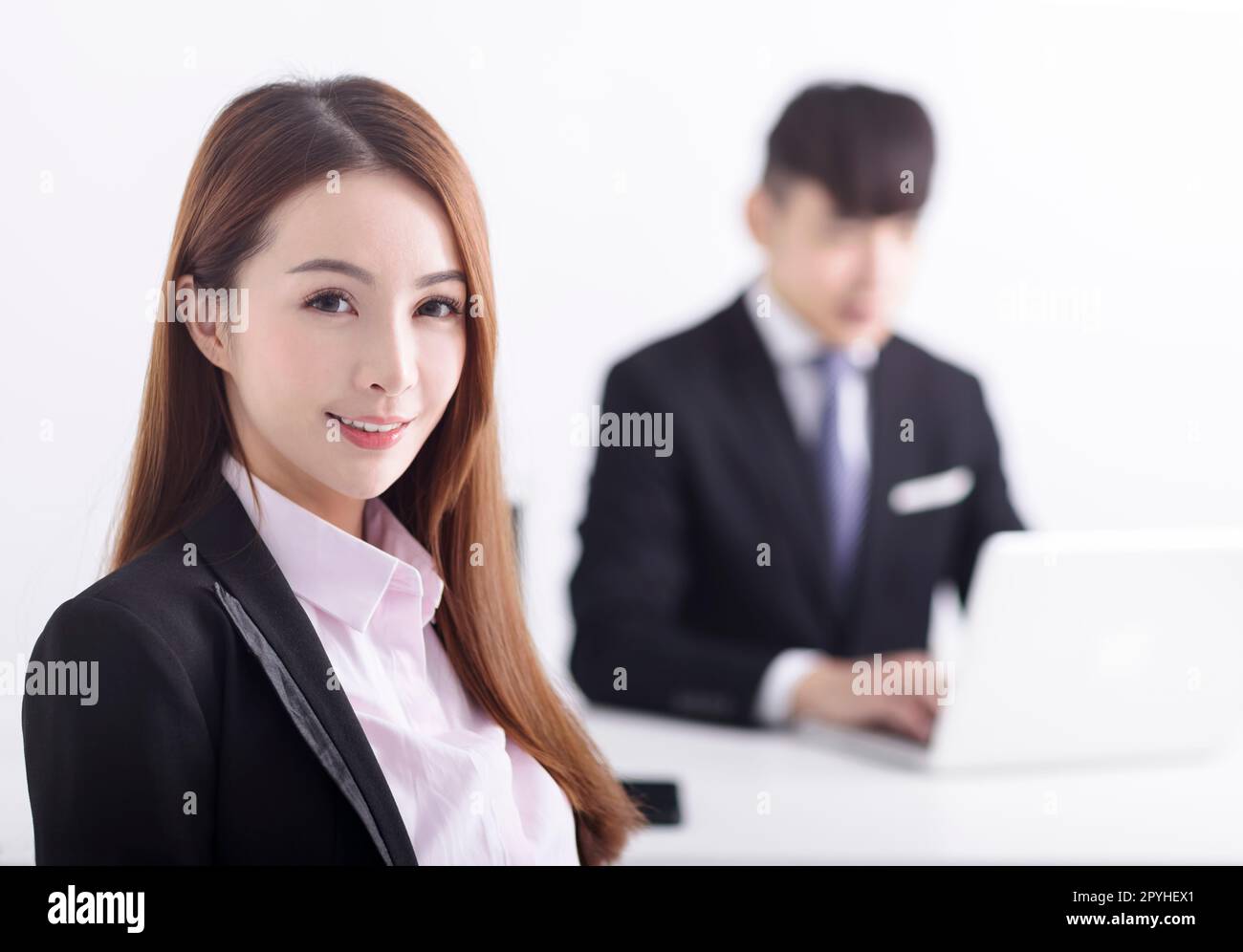 Successful business woman sitting with her staff in background at ...