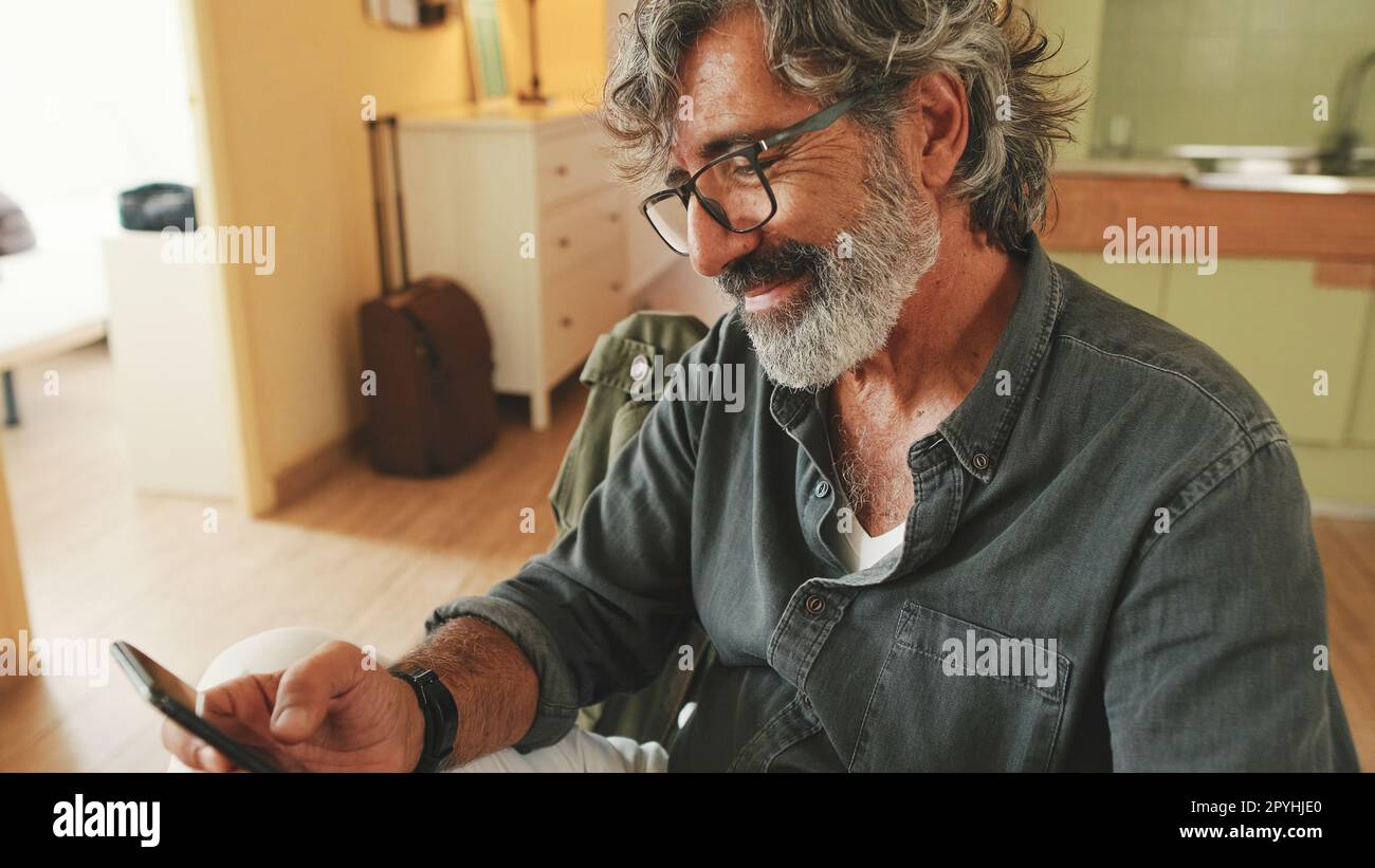 Close-up of an elderly man attentively reading message on his ...