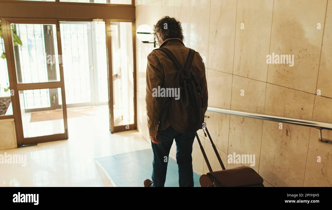 Middle aged man leaving home with luggage Stock Photo - Alamy