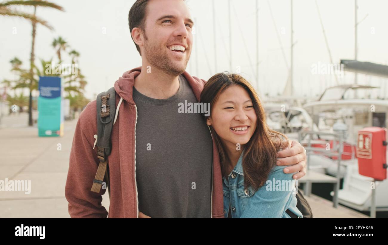 Young happy couple walking hugging along the promenade Stock Photo - Alamy