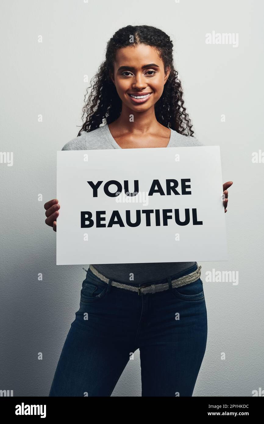 Just being yourself is beautiful. Studio shot of an attractive young woman holding a placard ...