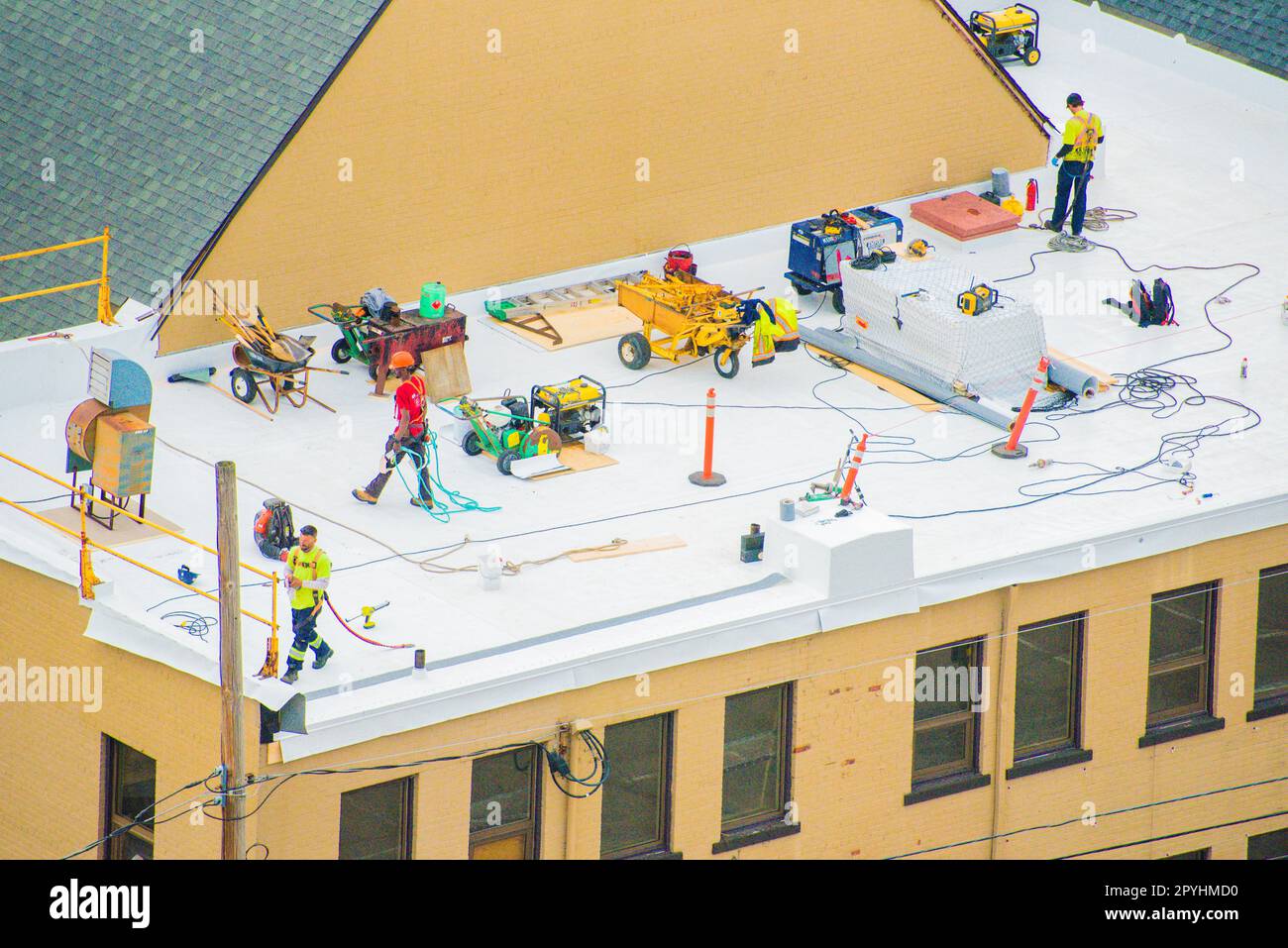 Multiple workers working on a rooftop doing construction Stock Photo ...