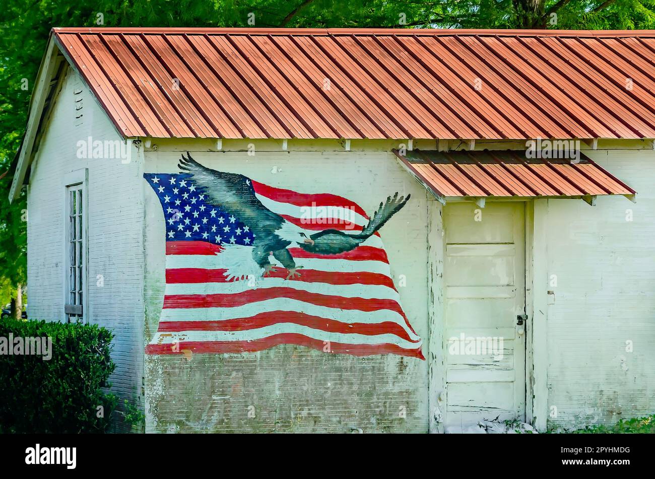 An eagle with an American flag is painted on the side of an abandoned ...