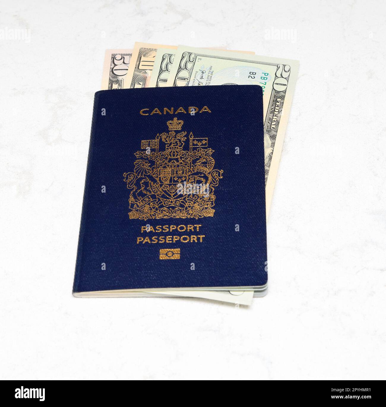 Canadian Passport and American dollars on a white marble background ...