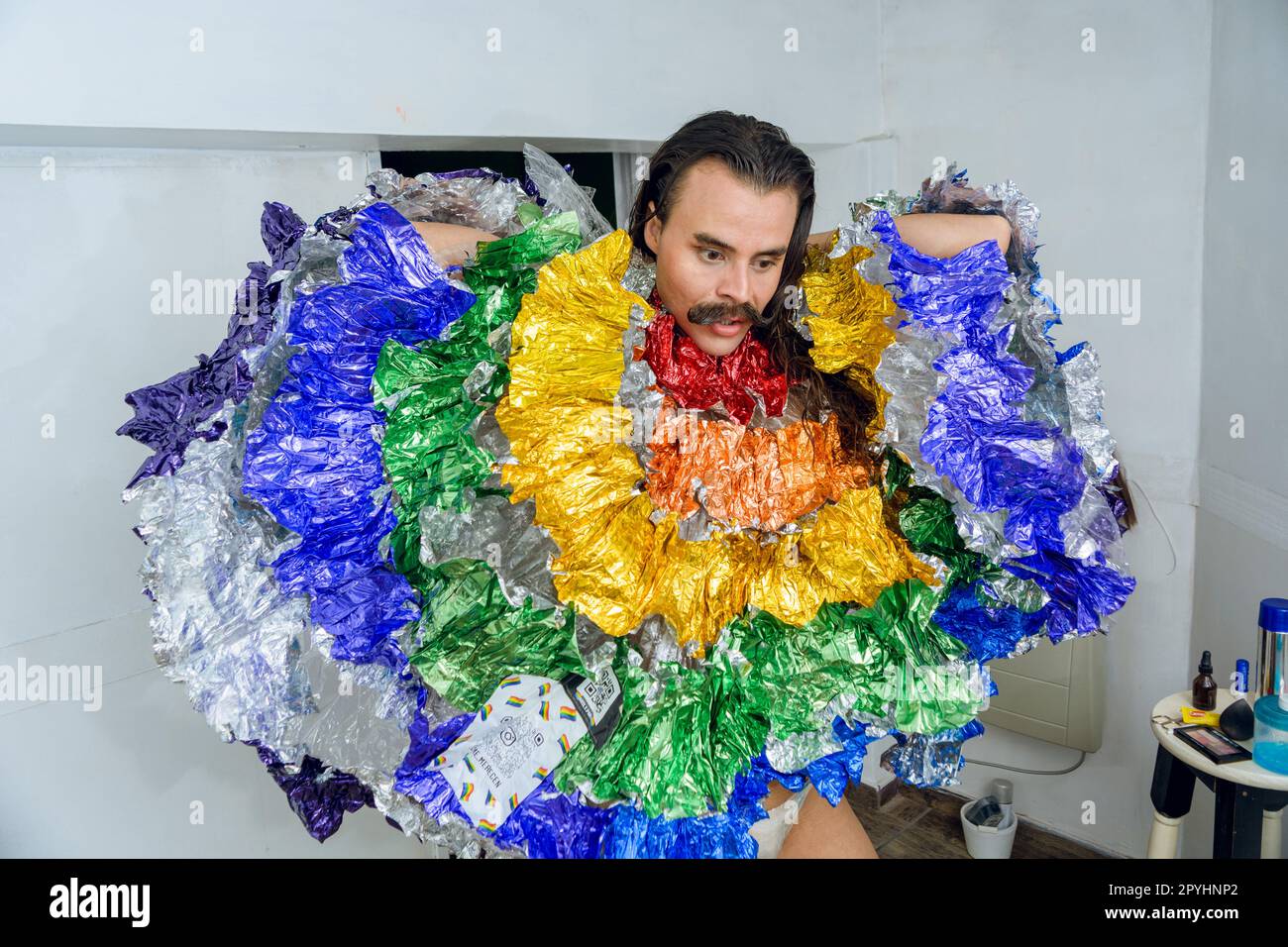 young latin person of non-binary gender with long hair and mustache, is ...