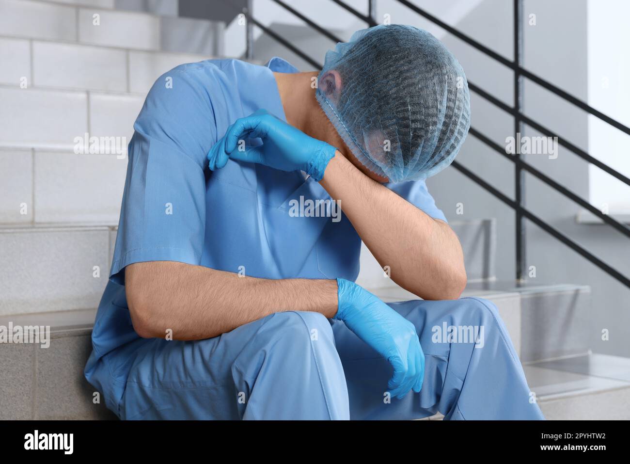 Exhausted doctor sitting on stairs in hospital Stock Photo - Alamy