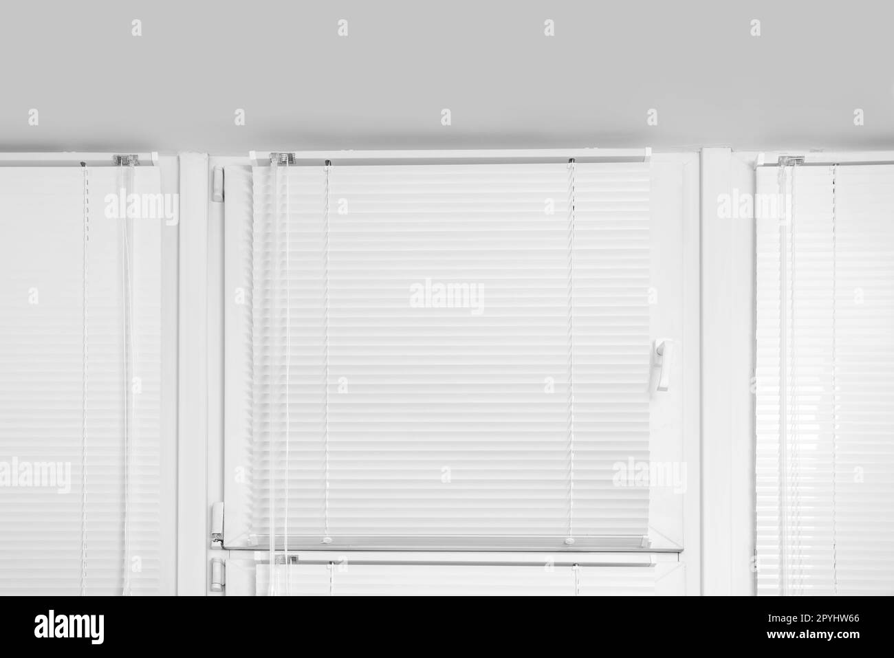 Window with closed white horizontal blinds indoors, low angle view ...