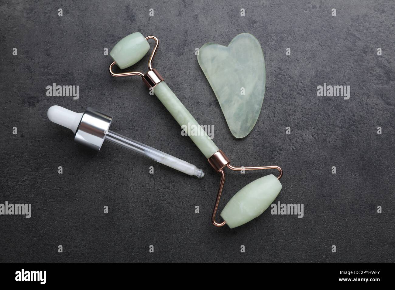 Quartz gua sha tool, face rollers and dropper with cosmetic product on ...