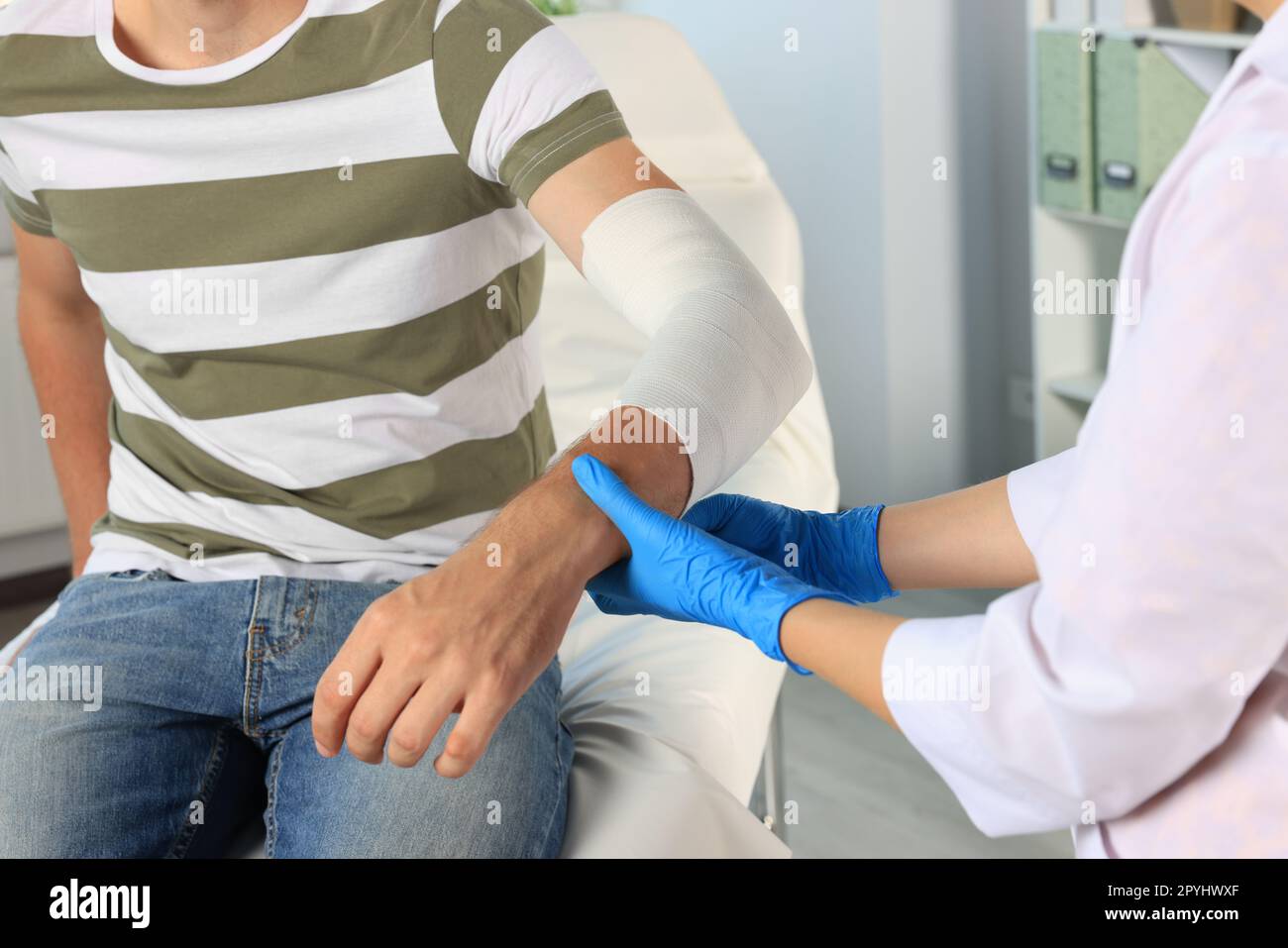 Doctor applying bandage onto patient's arm at hospital, closeup Stock ...