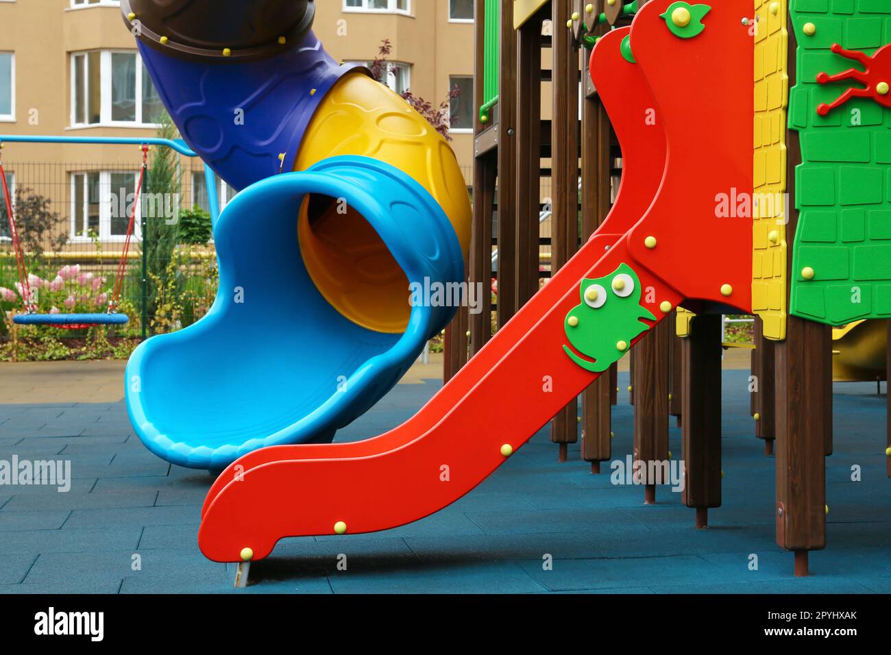 Colourful slides on outdoor playground for children in residential area ...