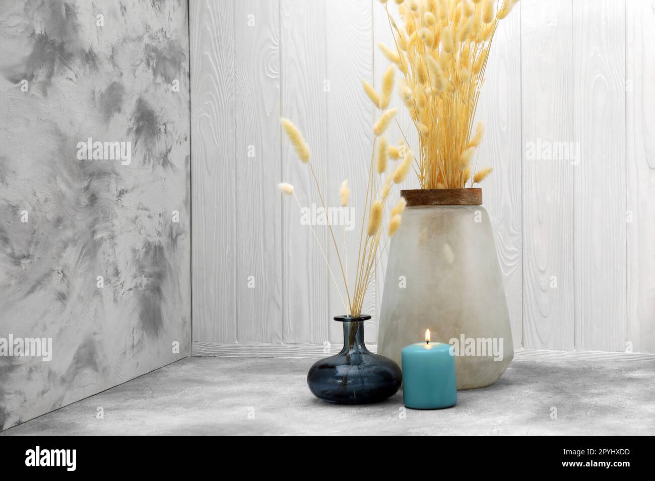 Vases with beautiful dry flowers, candle and double-sided backdrops in ...