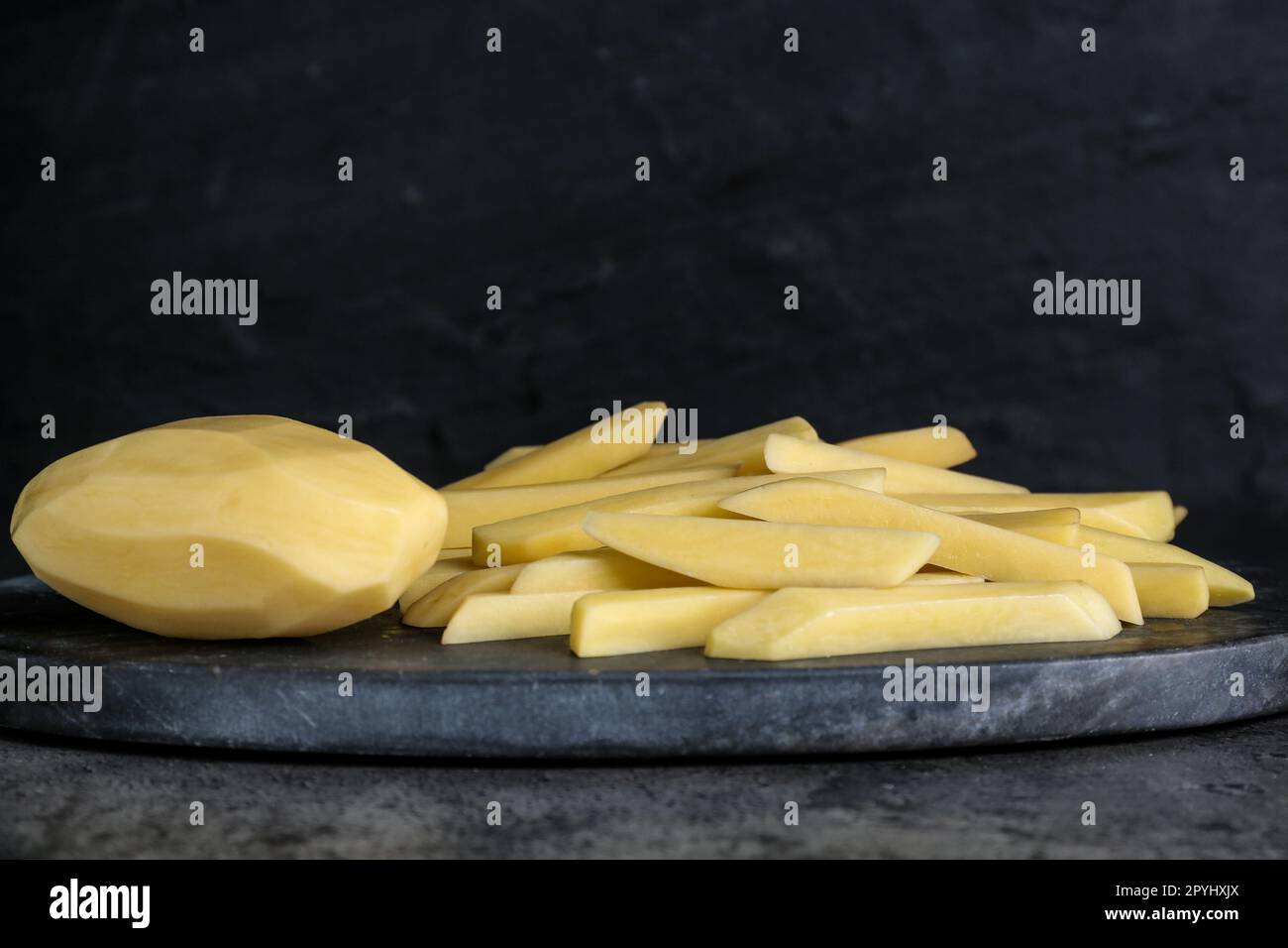 Whole and cut raw potatoes on grey table, closeup. Cooking delicious ...