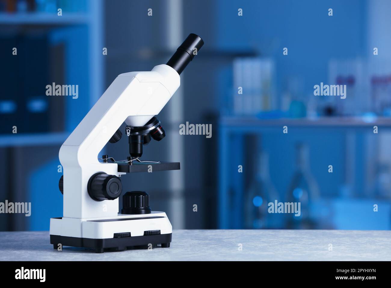 Modern medical microscope on gray table in laboratory, space for text ...