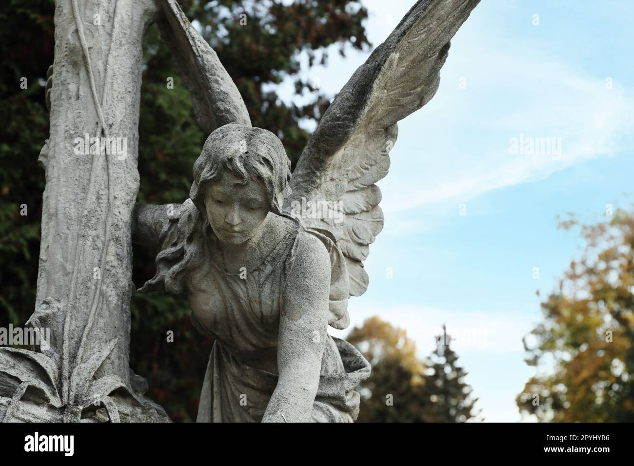 Beautiful statue of angel at cemetery, space for text. Funeral ceremony ...