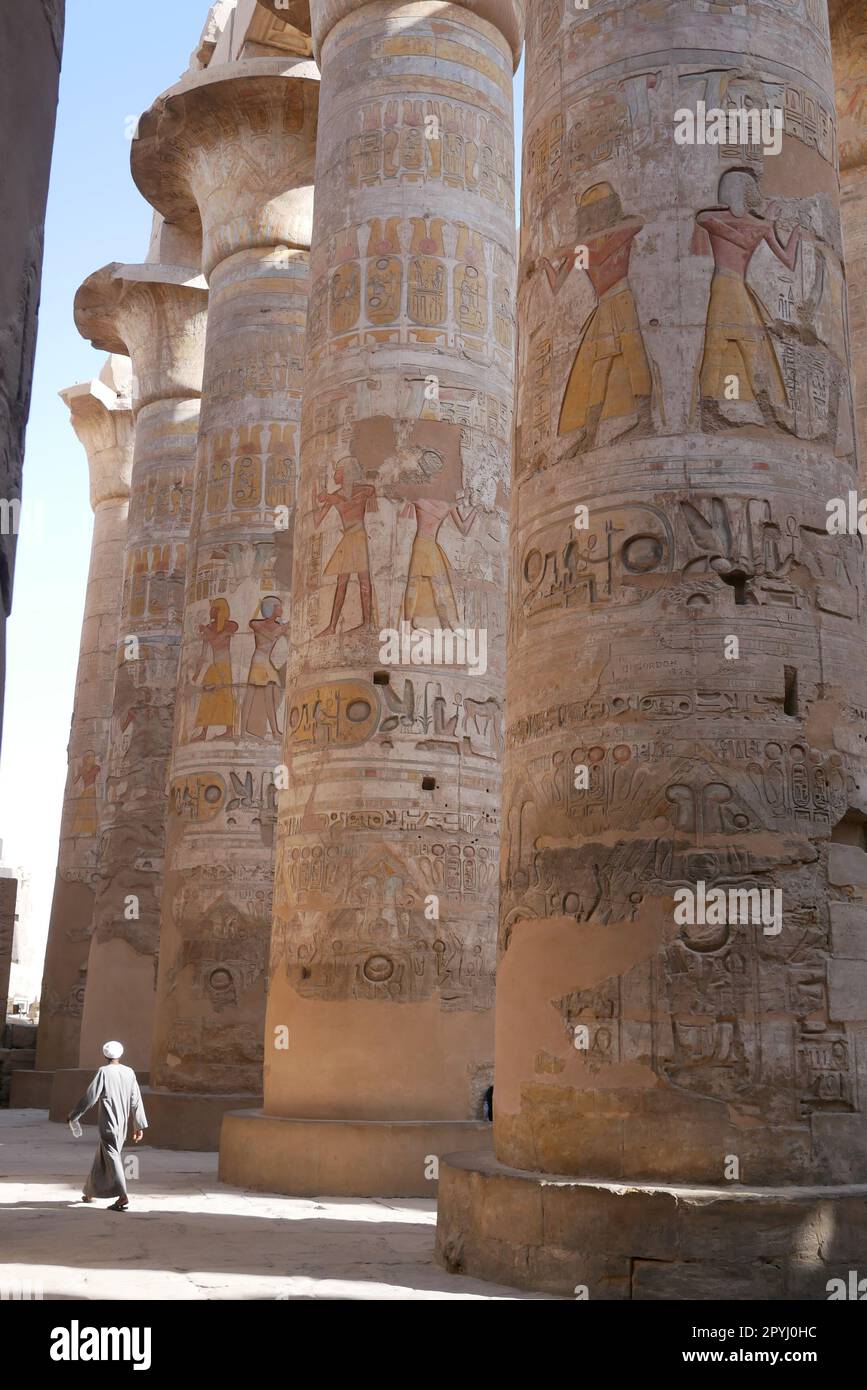 Caretaker walking under the great papyrus pillars at the temple of ...