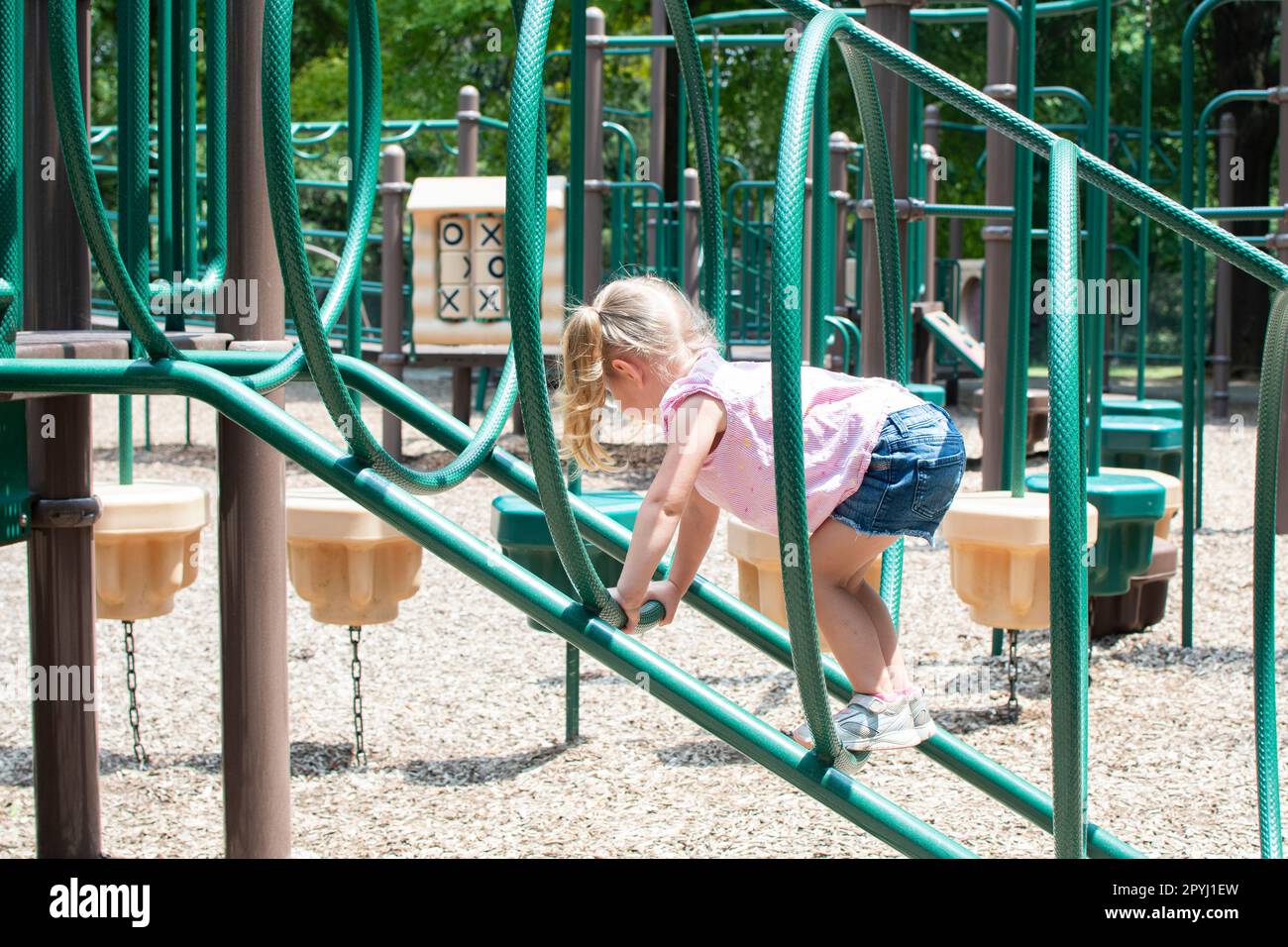 Cute Caucasian toddler girl playing at the playground. Climbing kid ...