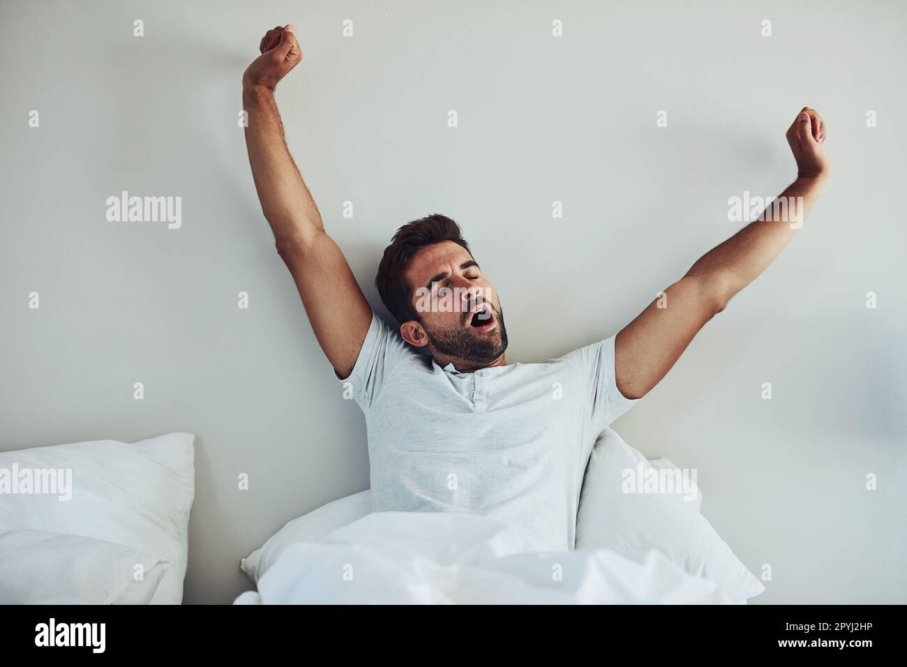 What a good night of sleep. a tired young man waking up after a good ...