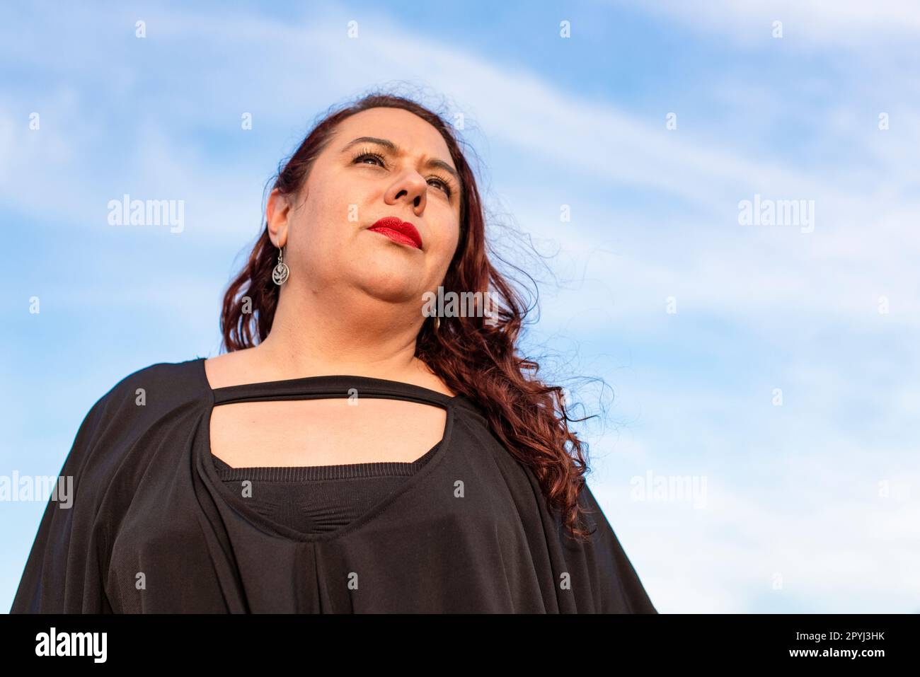 Low angle view of a plus-size woman. Blue sky background Stock Photo ...