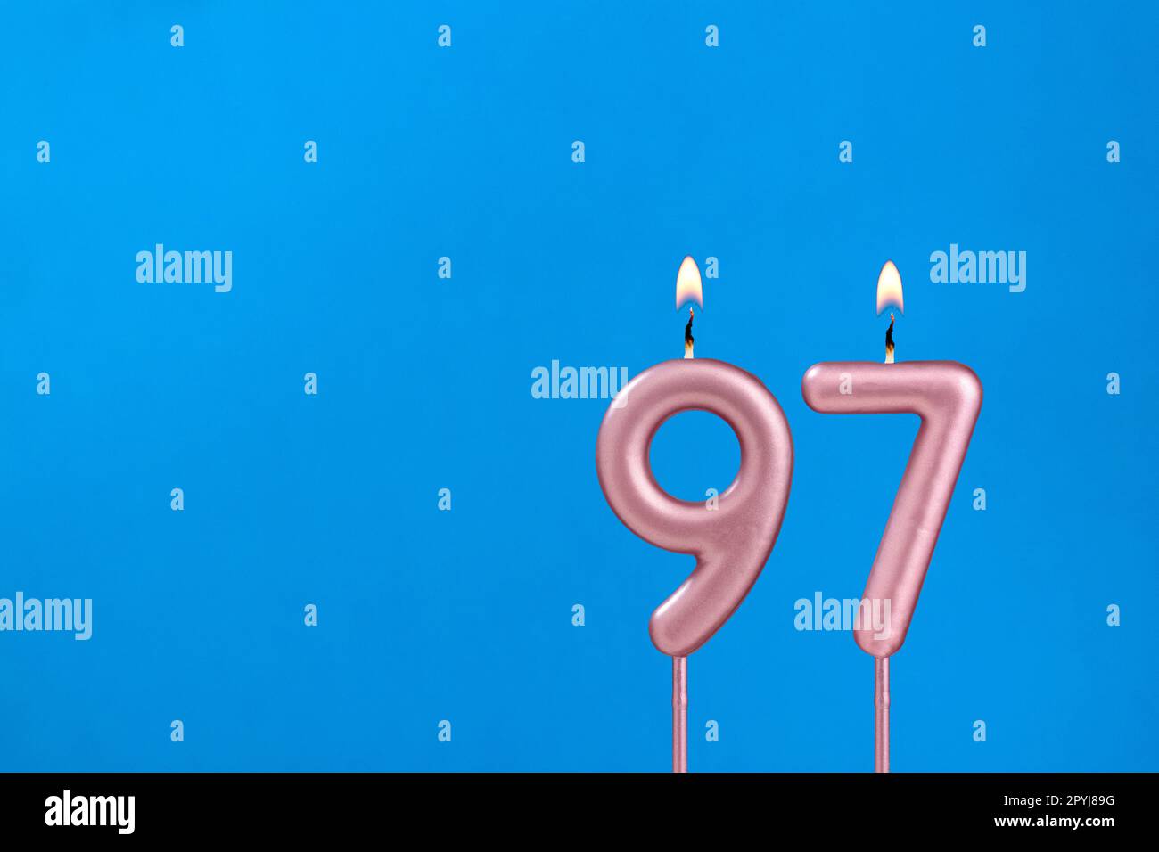 Number 97 - Burning anniversary candle on blue foamy background Stock ...