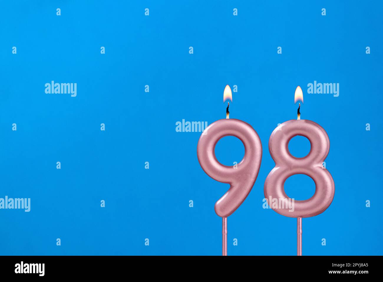 Candle number 98 - Birthday in blues foamy background Stock Photo - Alamy
